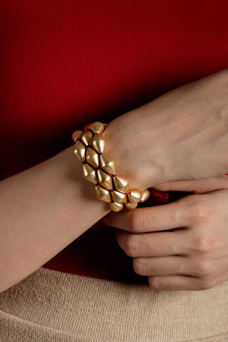 Buy Gold Plated Red Thread Dholki Paunchi Bracelet by Neeta Boochra ...