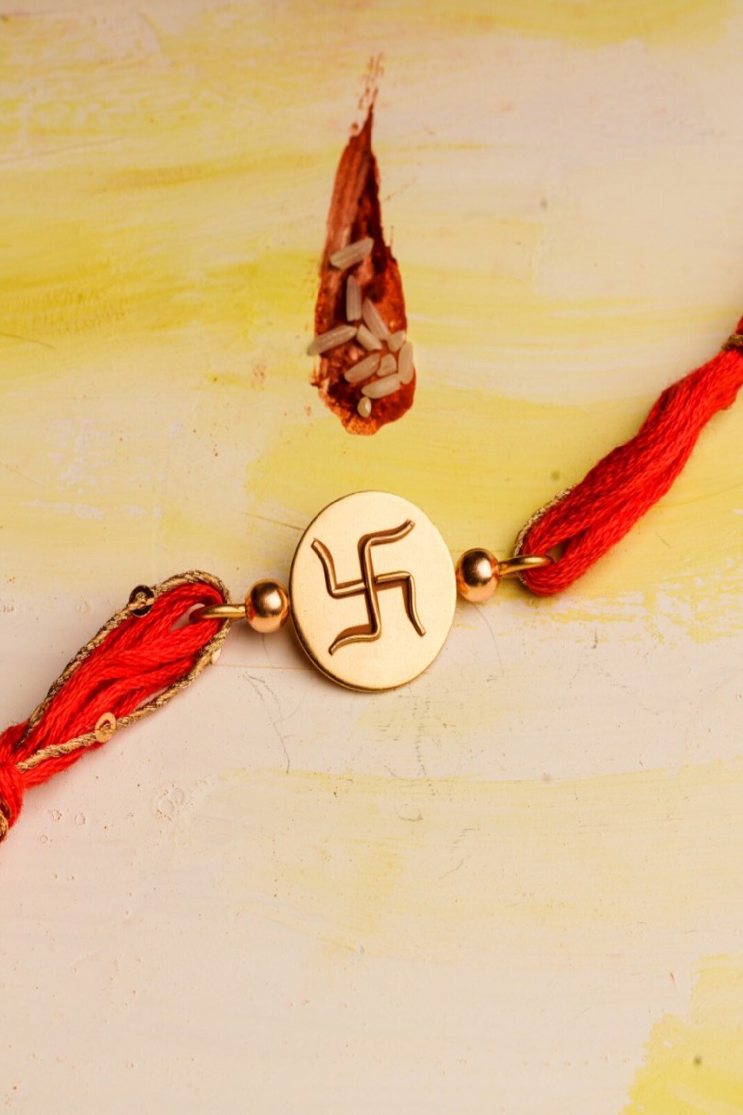 Buy Gold Bead Swastika Motif Rakhi by SUHANI PITTIE Online at Aza Fashions.